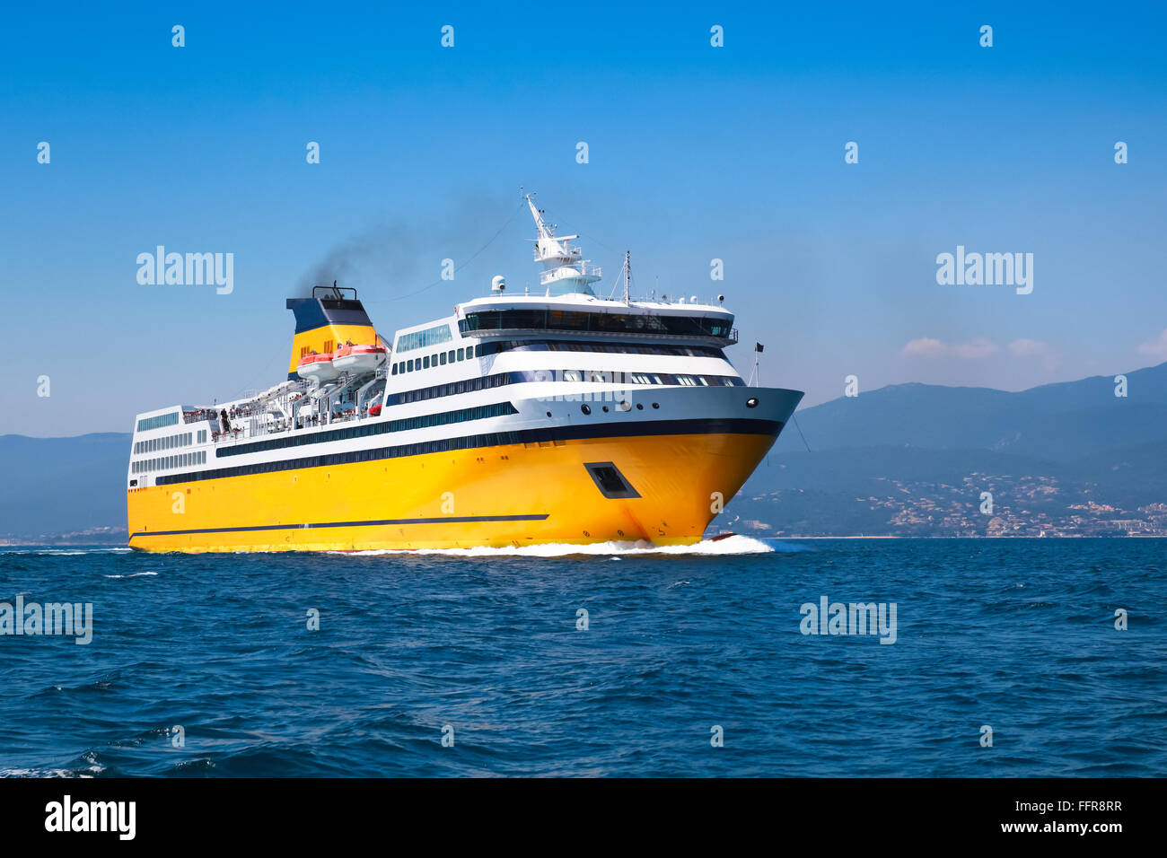 Big yellow passenger ferry goes on the Mediterranean Sea near Corsica ...