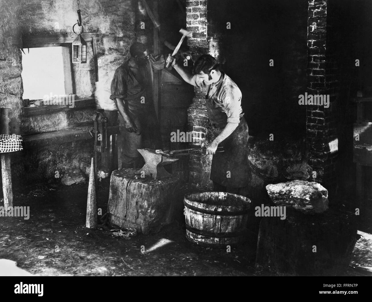 BLACKSMITH AT WORK. /nA blacksmith and assistant at work. Undated ...