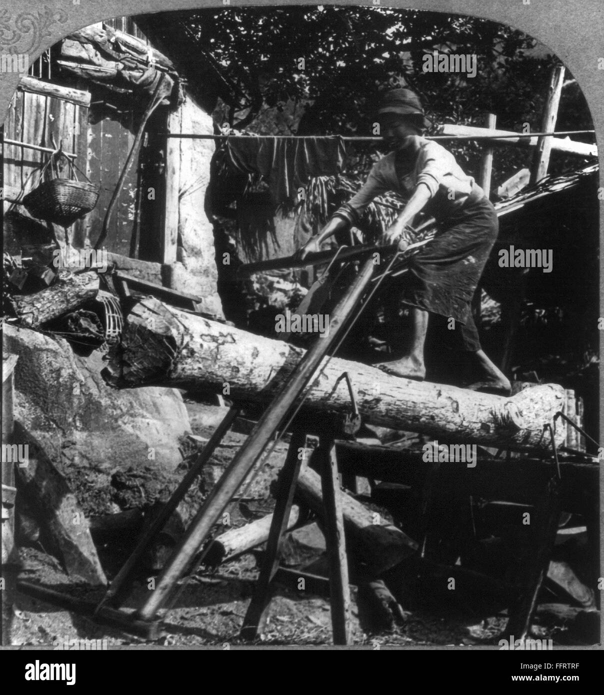 CHINA: SAW MILL, c1902. /nA Chinese boy standing on top of a log while ...