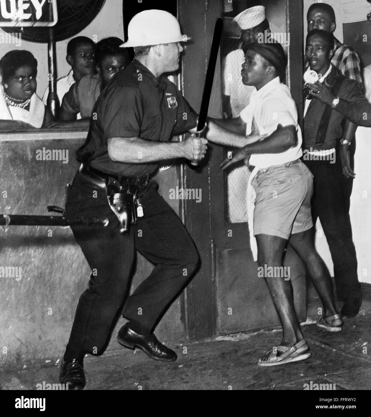 HARLEM: RACE RIOTS, 1964. /nA policeman confronts a group of African ...