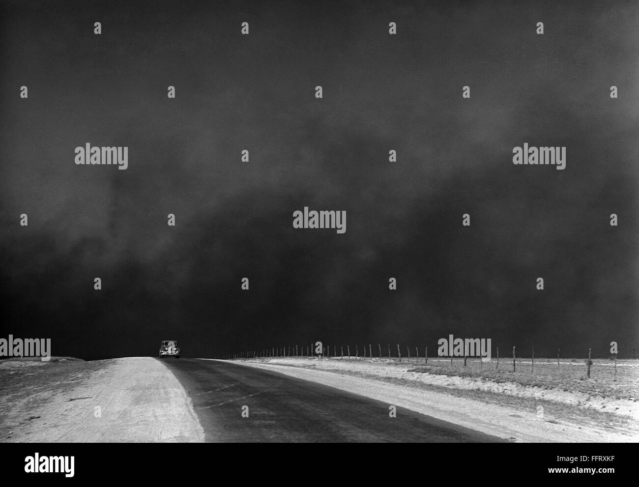 DUST BOWL, 1936. /nA car on a deserted road with black clouds of dust ...