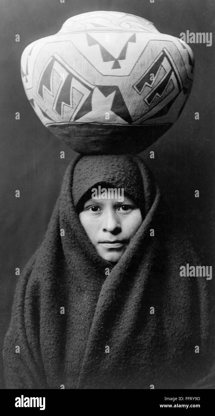 ZUNI GIRL WITH JAR, c1903. /nA Zuni girl wrapped in a blanket, carrying ...
