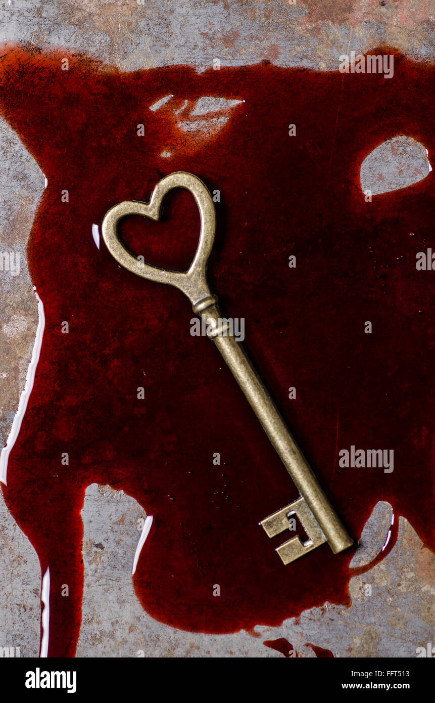 Heart shaped key in a pool of blood Stock Photo - Alamy