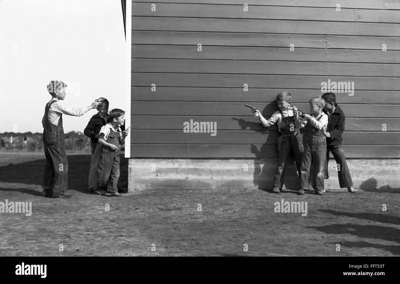 CHILDREN, 1942. /nSix boys playing a game of cowboys and Indians at a ...