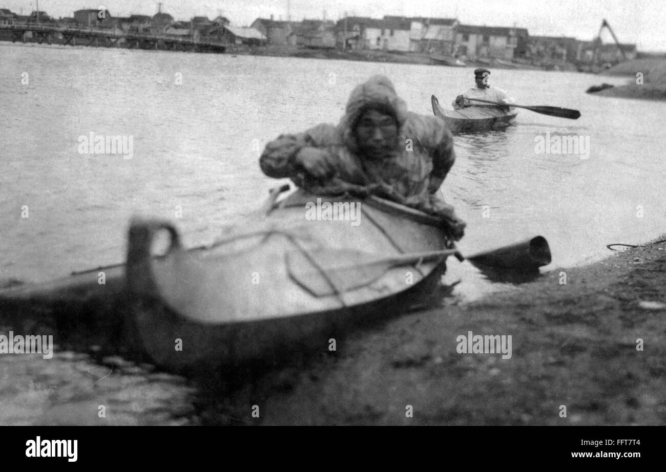 ALASKA: KAYAKING. /nAn Eskimo man landing on the shore in a kayak with ...