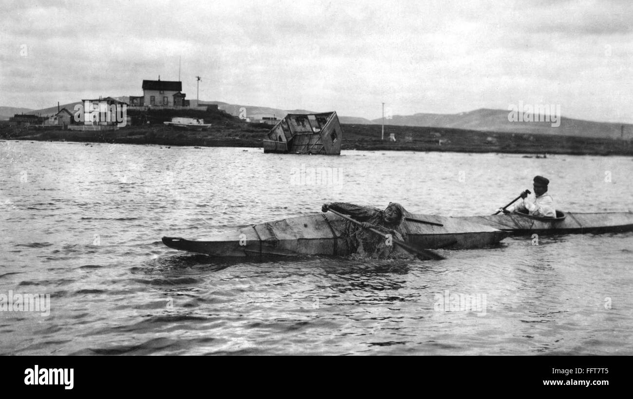 ALASKA: KAYAKING. /nTwo Eskimo men kayaking, one of them falling in the ...