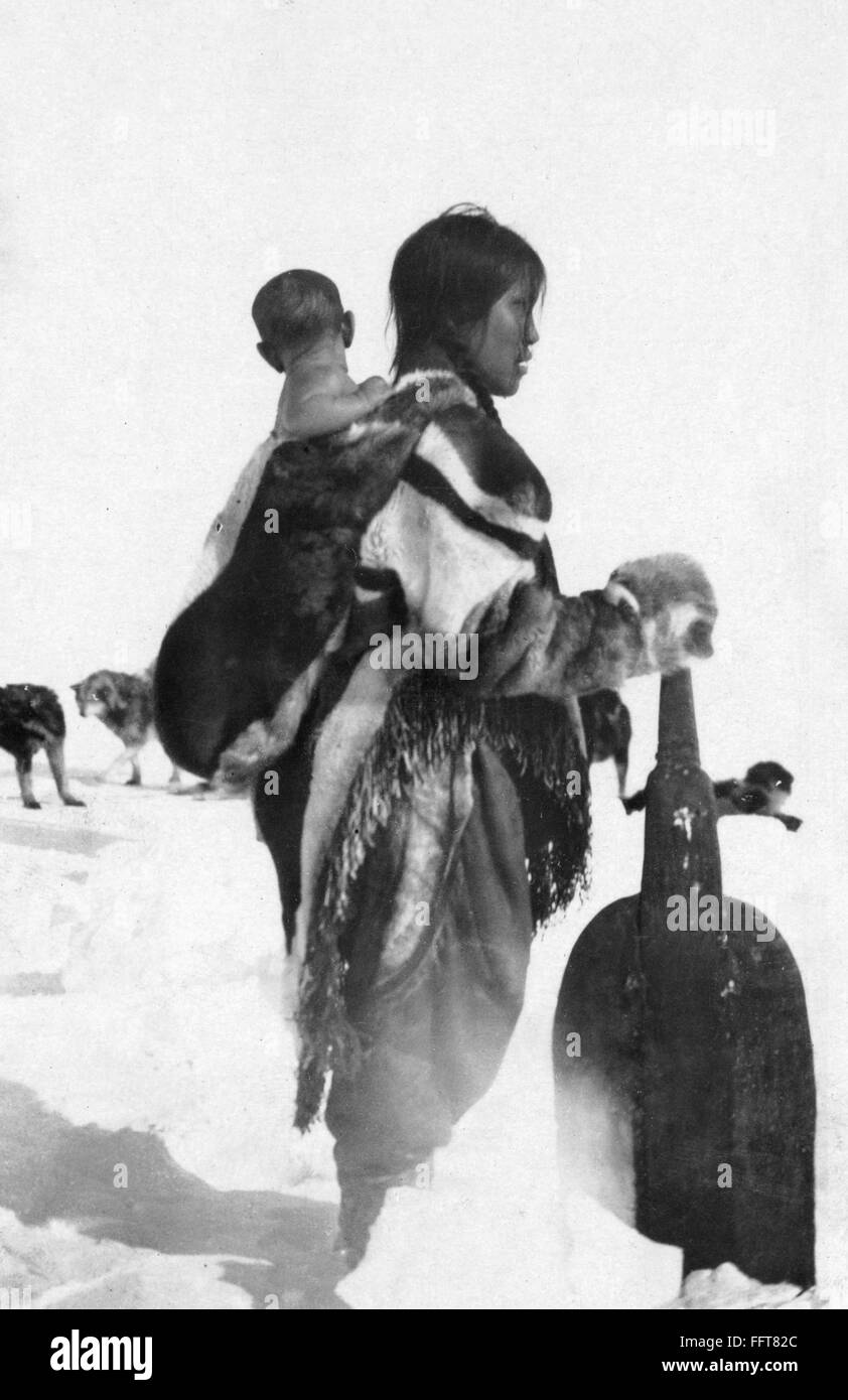 CANADA: ESKIMOS. /nA Netselingmeut woman holding a snow shovel with a ...