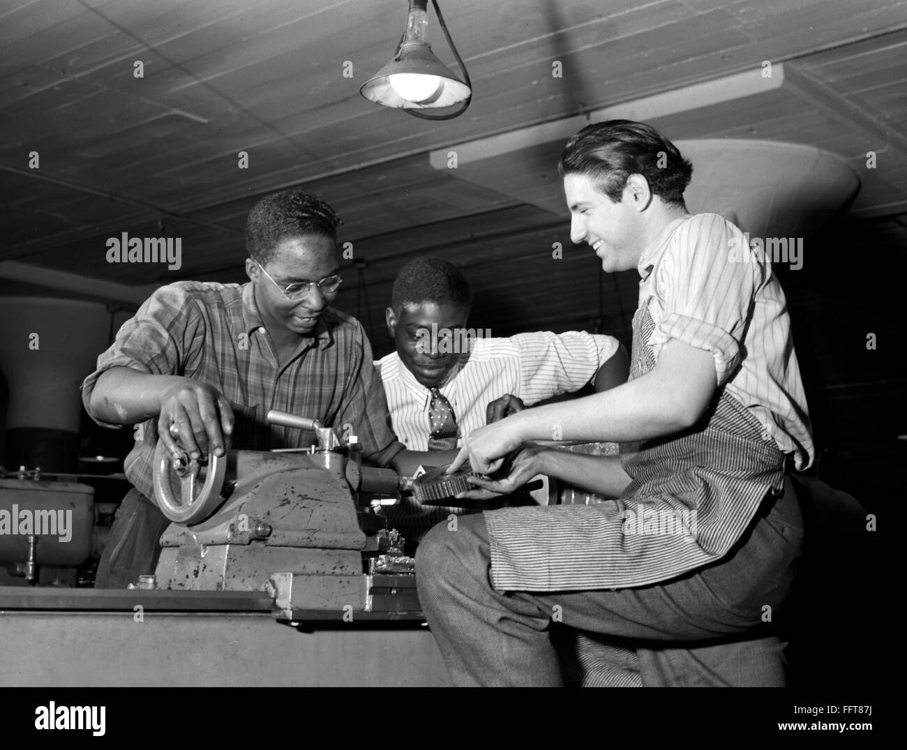AMERICAN WORKERS, c1941. /nThree American workers using a power tool in ...