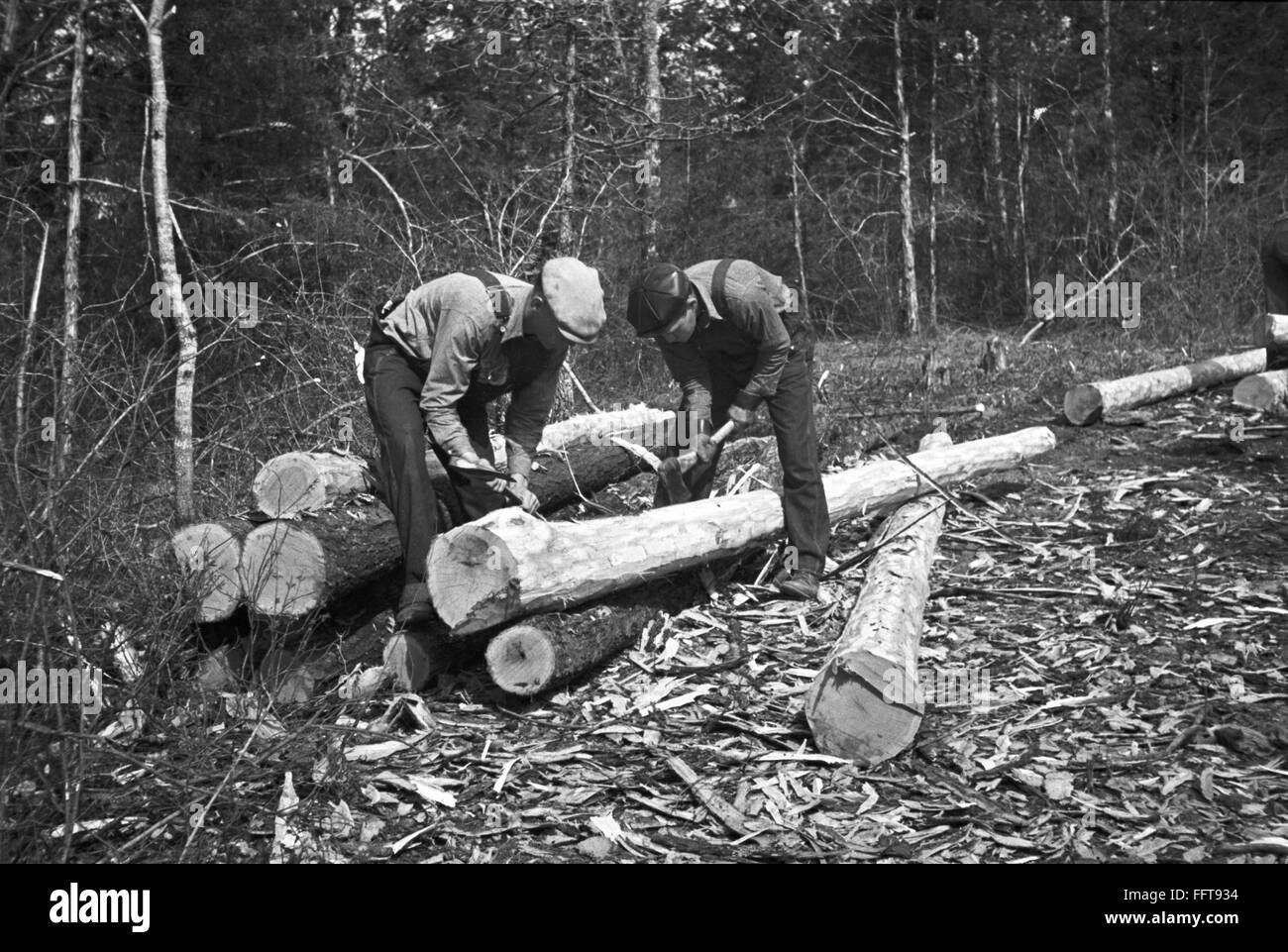 LOG STRIPPERS, 1936. /nTwo carpenters stripping logs for shelters at ...