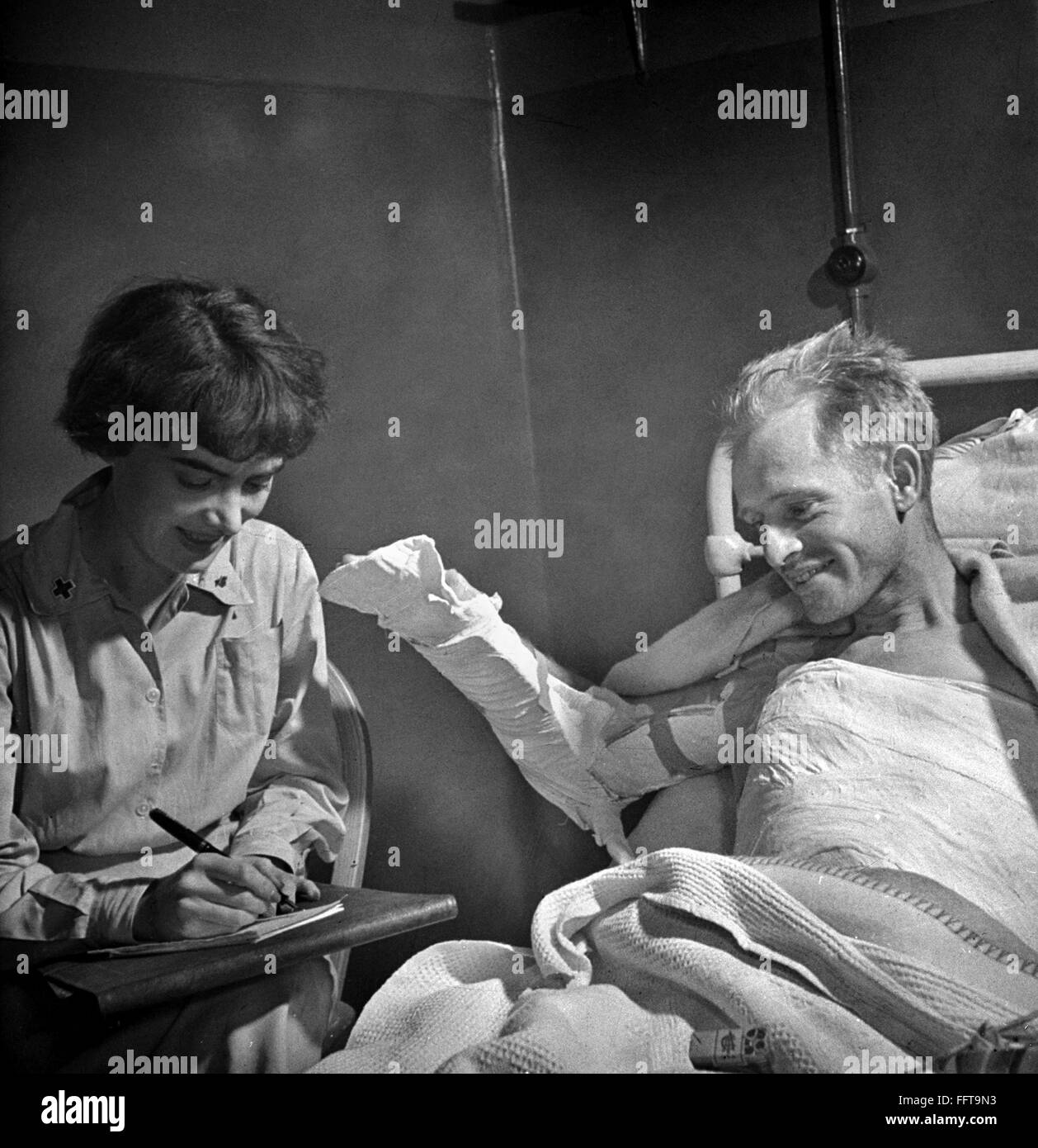 WOUNDED SOLDIER, 1942. /nA wounded American soldier being assisted by a ...