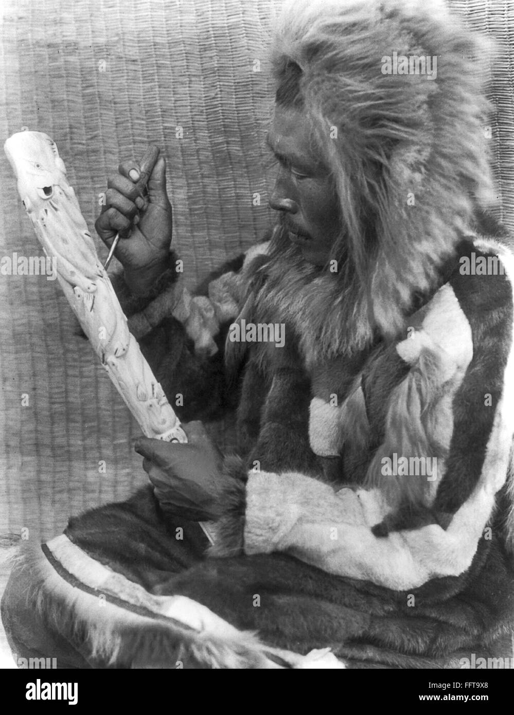 ALASKA: ESKIMO MAN, c1929. /nA seated Eskimo man carving an ivory tusk ...