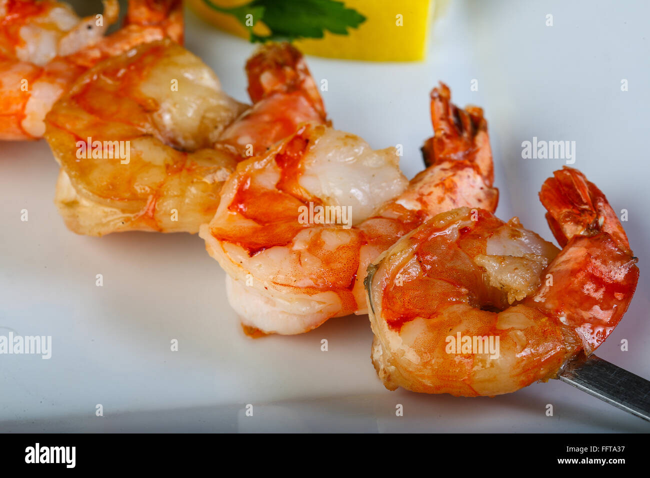 Tiger prawn skewer served sliced lemon and parsley Stock Photo - Alamy