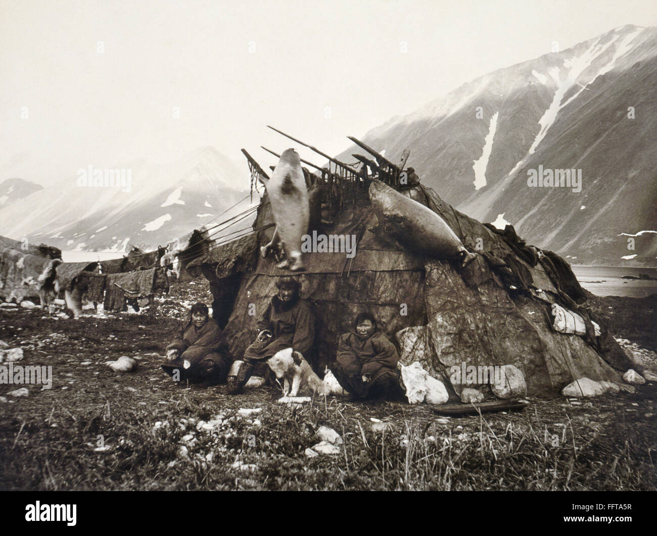 ESKIMO DWELLING, c1899. /nA group of three Inuits sitting in front of ...