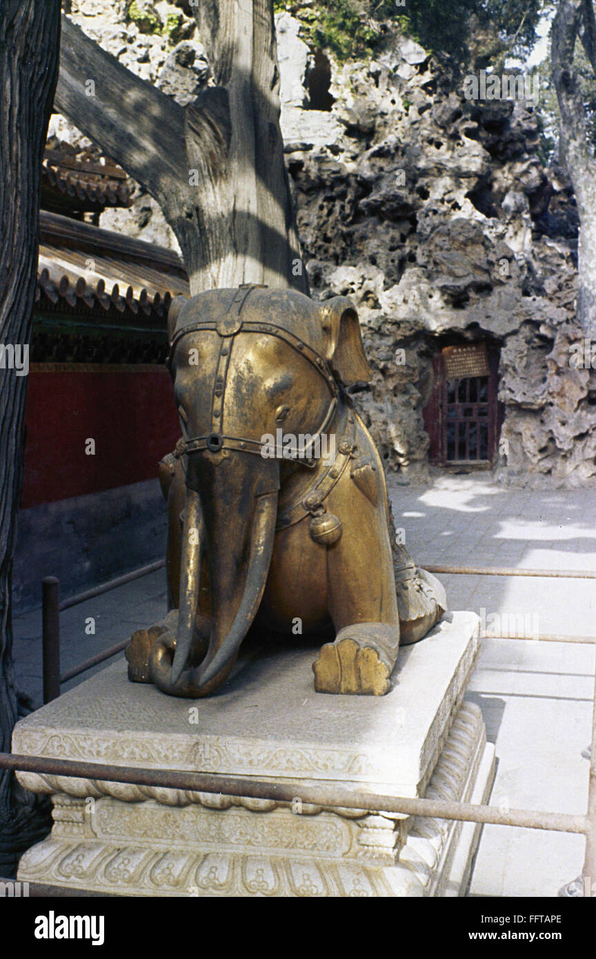 PEKING: ELEPHANT. /nBronze sculpture of a kneeling elephant in a garden ...