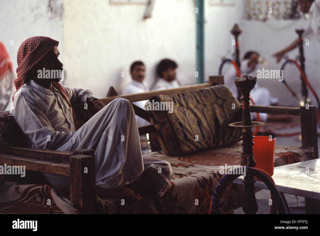 Men smoking waterpipe at an outdoor cafe in Al Khobar, in Saudi Arabia ...