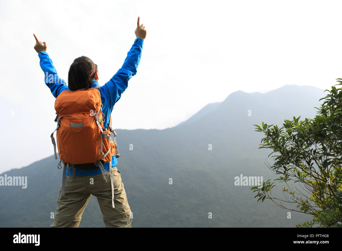cheering woman hiker open arms at mountain peak Stock Photo - Alamy