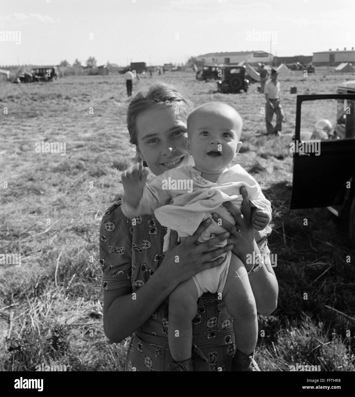 MIGRANT MOTHER, 1939. /nA migrant potato picker holding her baby in ...