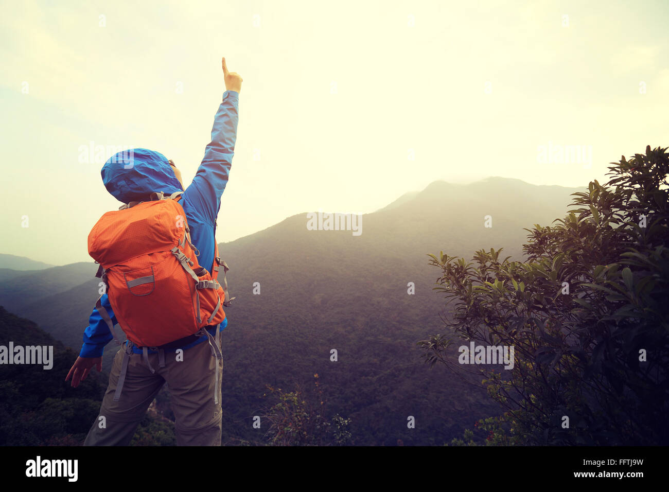 cheering woman hiker open arms at mountain peak Stock Photo - Alamy