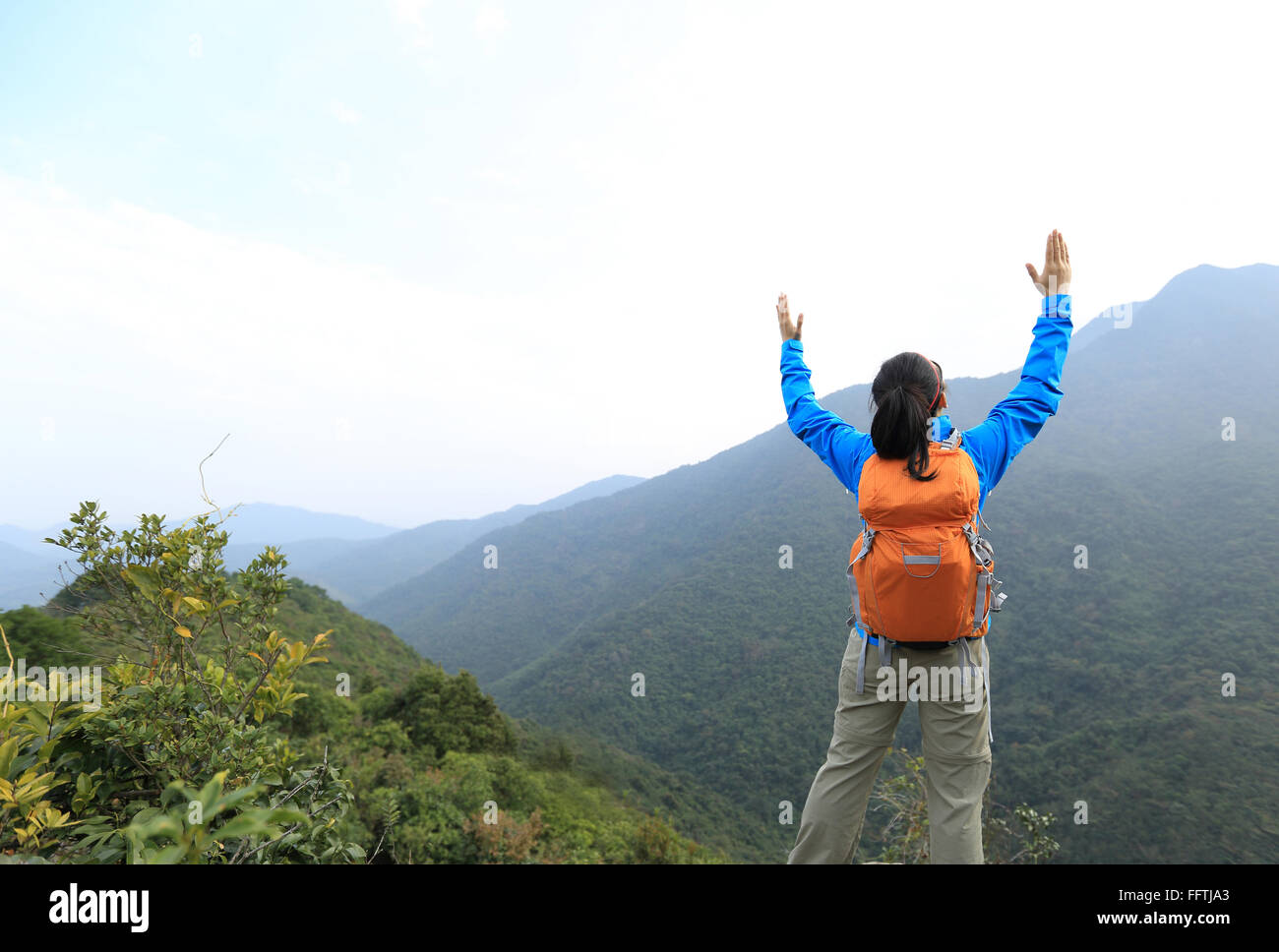 cheering woman hiker open arms at mountain peak Stock Photo - Alamy