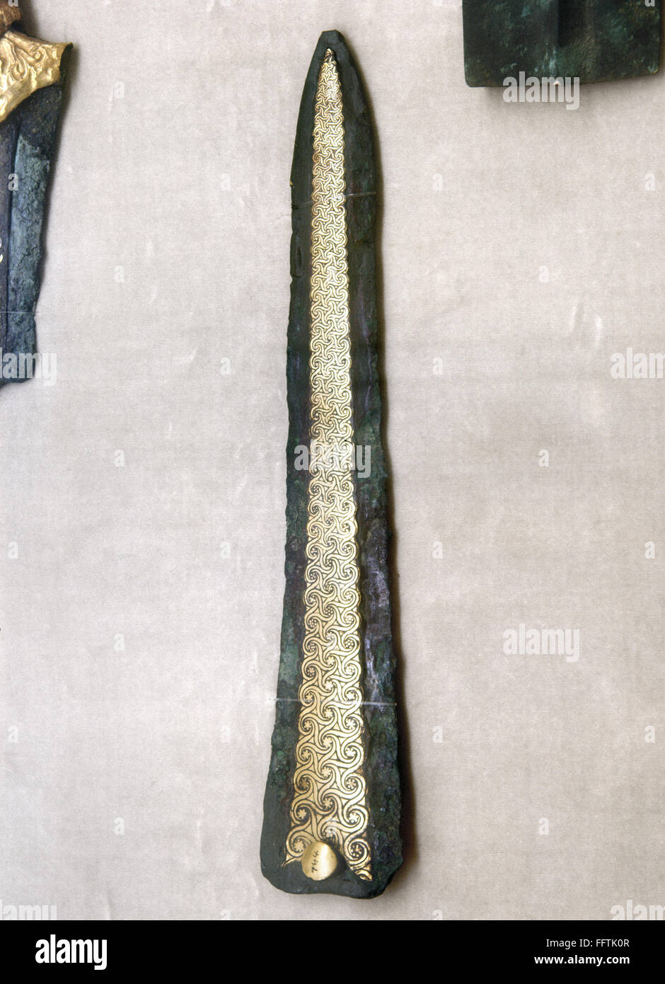 MYCENAEAN BRONZE. /nBronze dagger blade overlaid with a band of gold ...