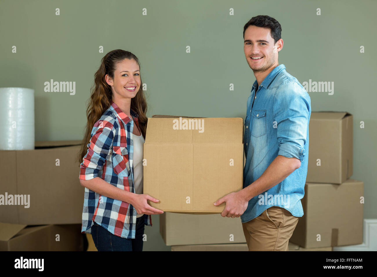 Young couple unpacking carton boxes in their new house Stock Photo - Alamy