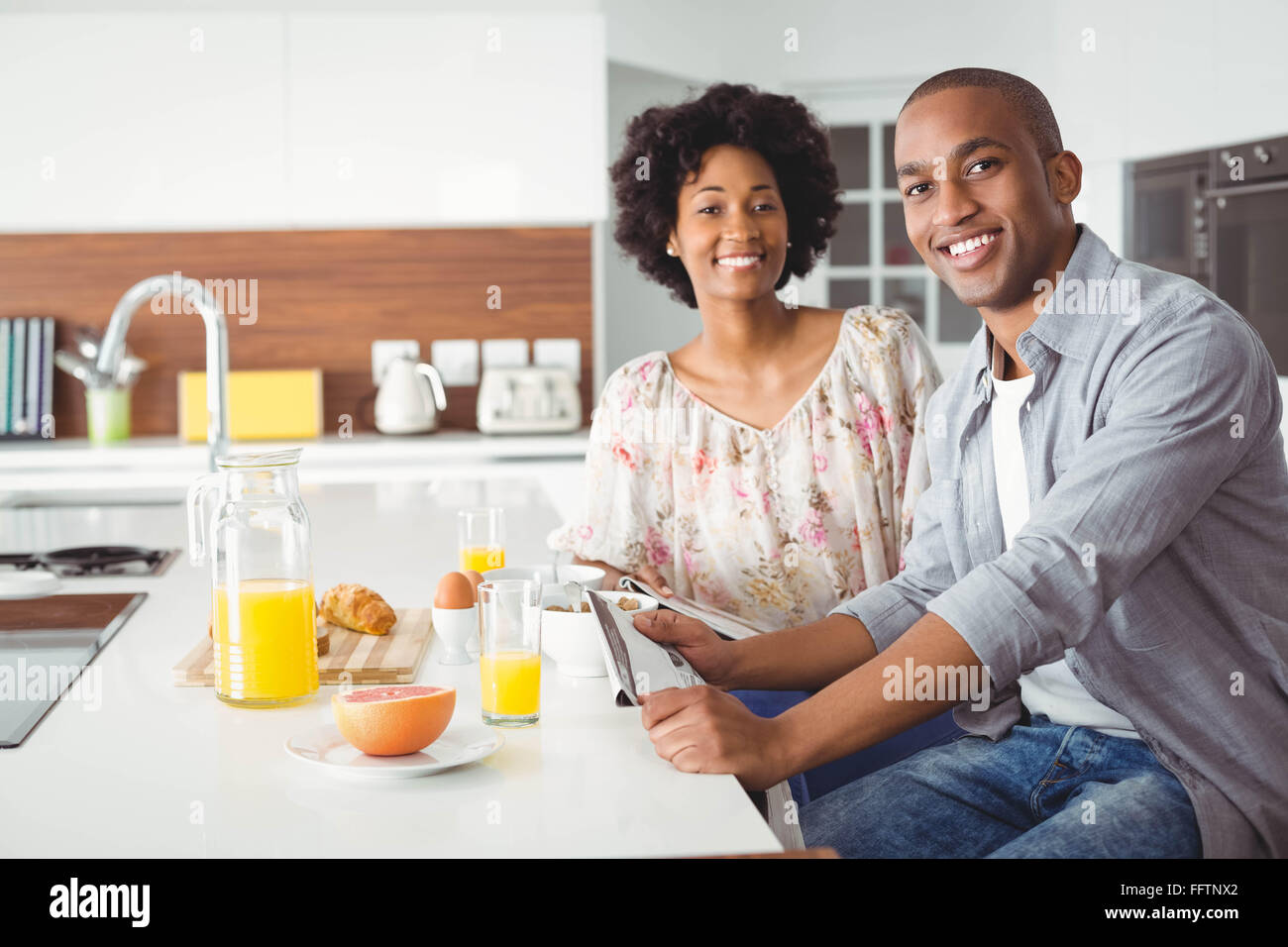 Smiling couple eating breakfast together in the kitchen Stock Photo - Alamy