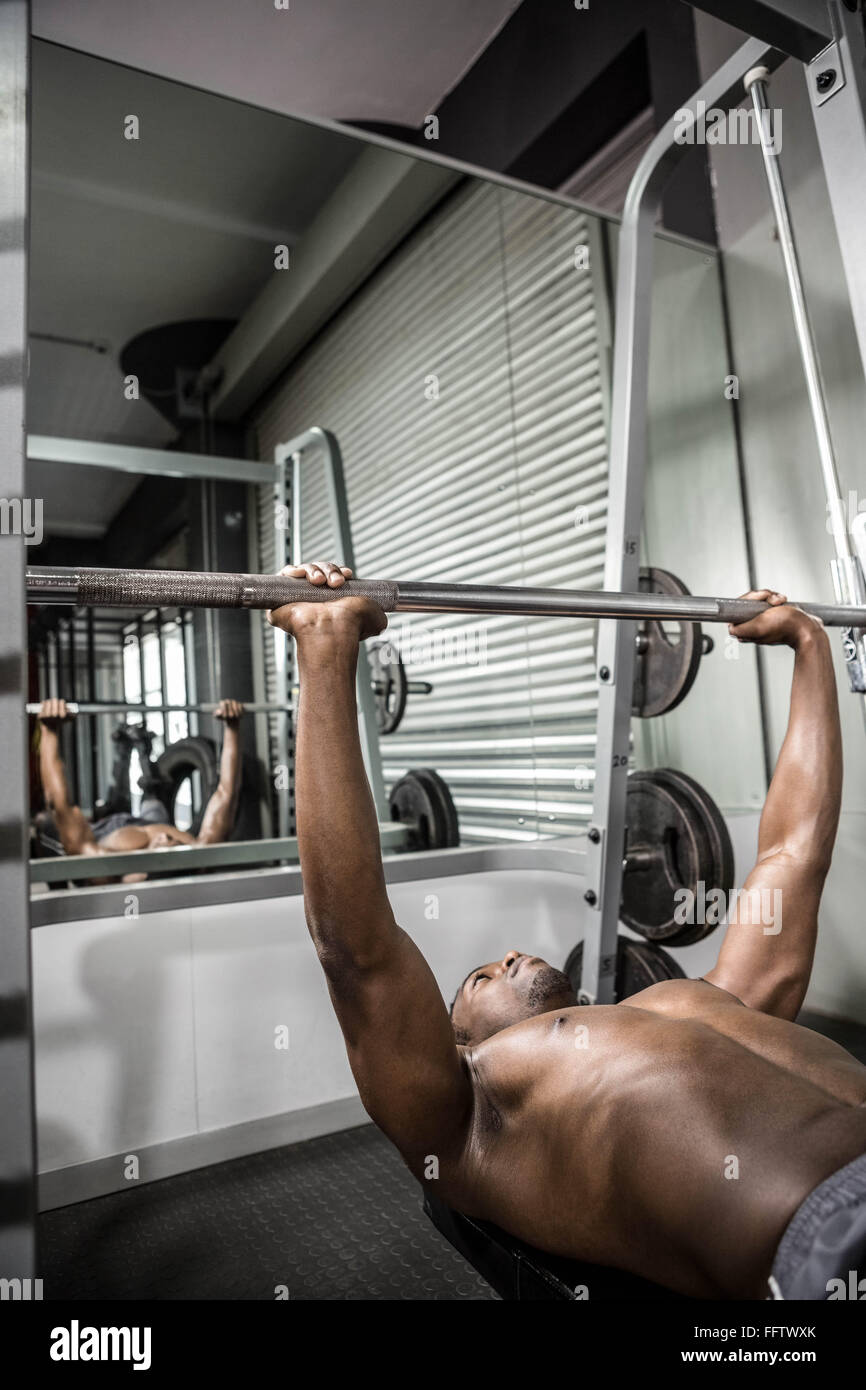 Shirtless man lifting barbell on bench Stock Photo - Alamy