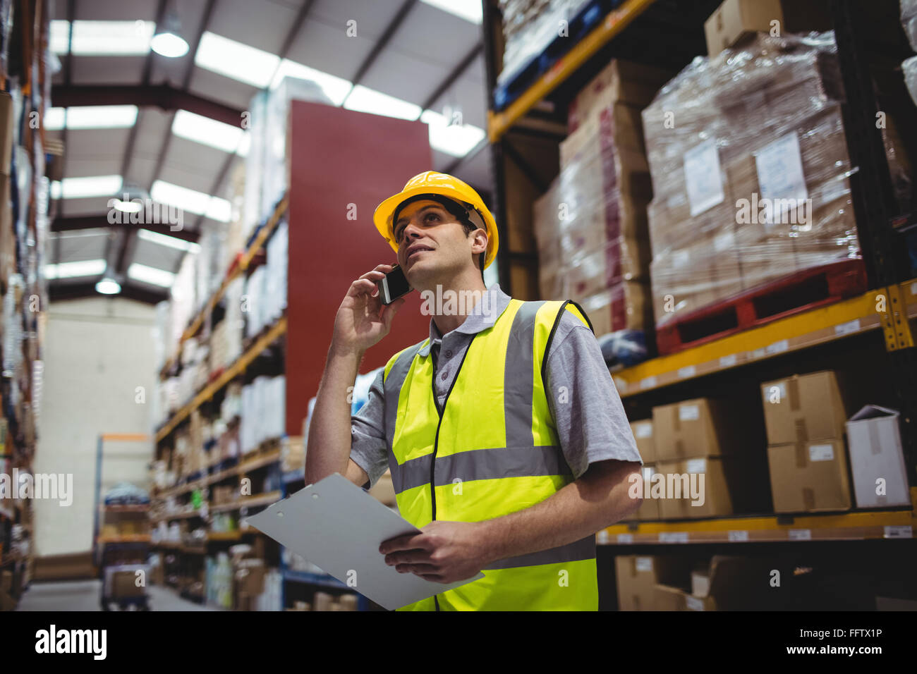 Warehouse worker on a phone call Stock Photo - Alamy