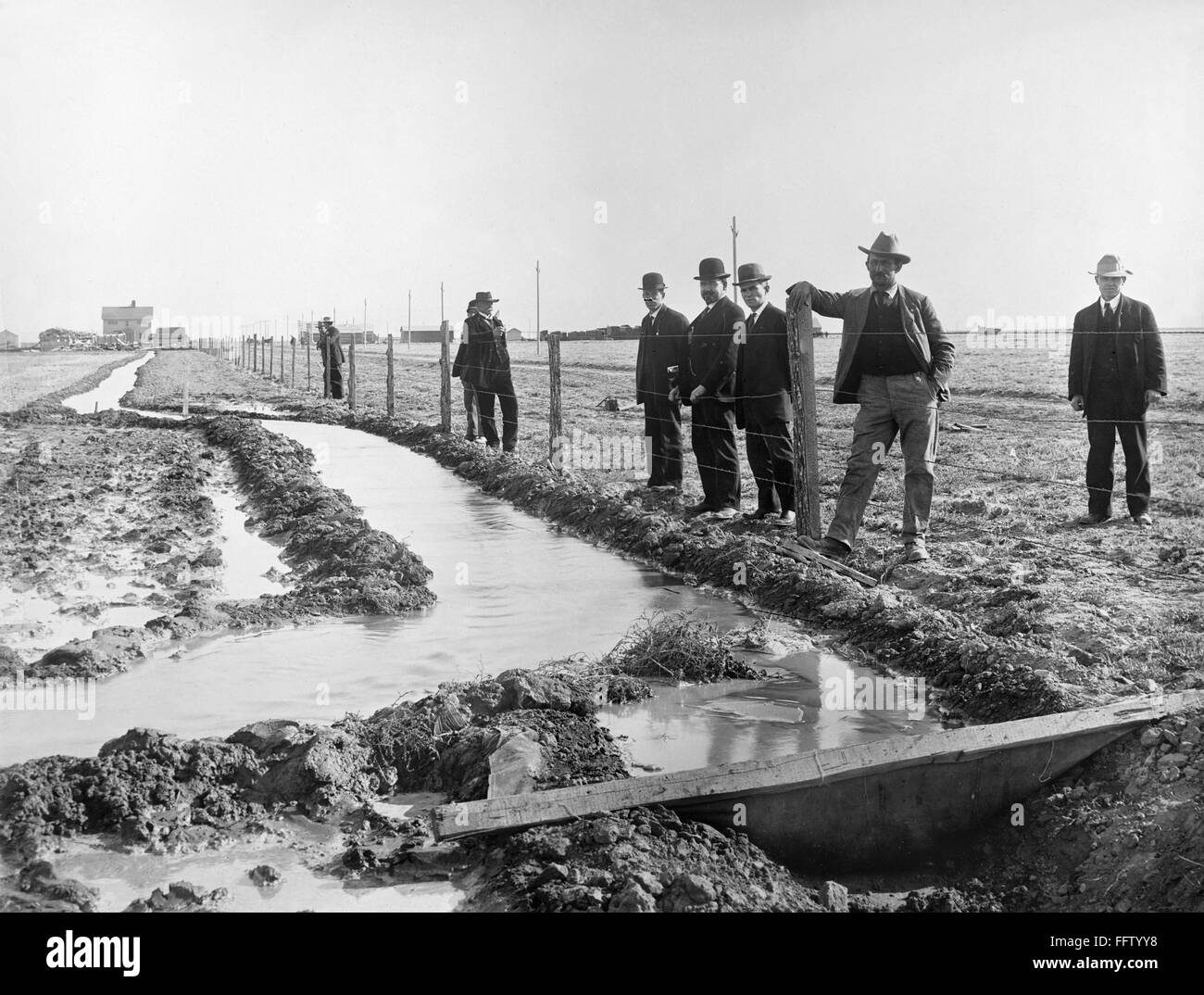 WYOMING: IRRIGATION, c1915. /nA group of men standing behind a barbed ...