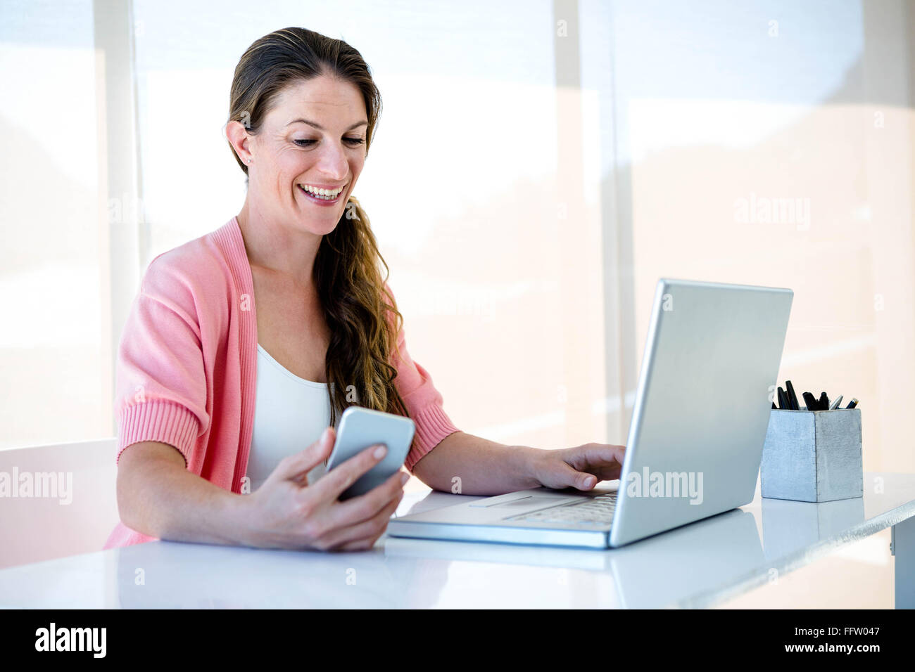 smiling woman on her laptop and smartphone Stock Photo - Alamy