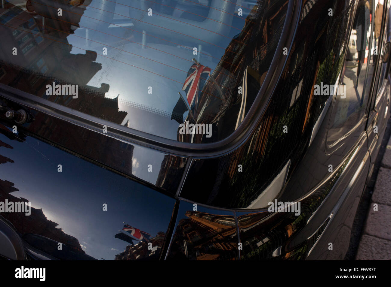 Reflections of blue sky, surrounding buildings and union Jack flag ...