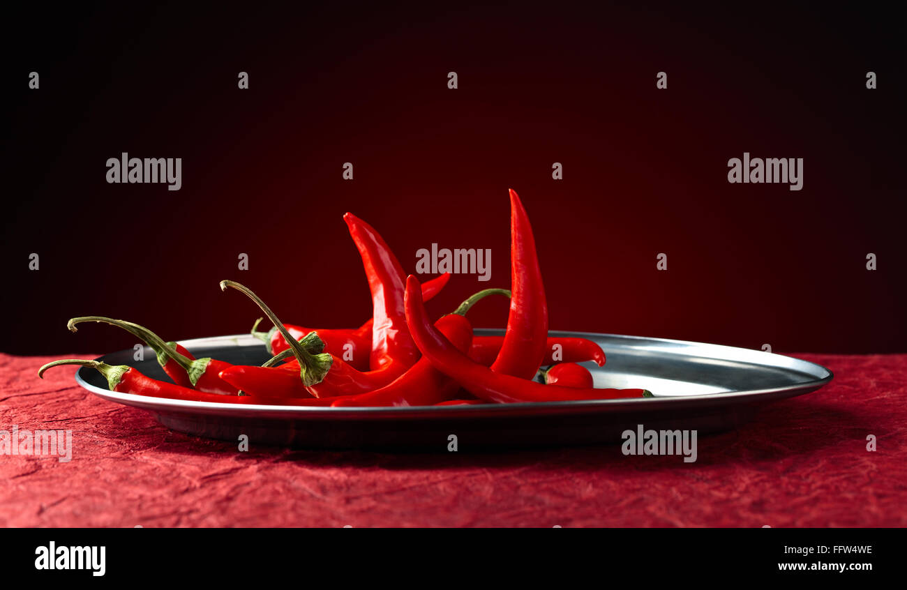 beam of chilli pepper on red background Stock Photo - Alamy