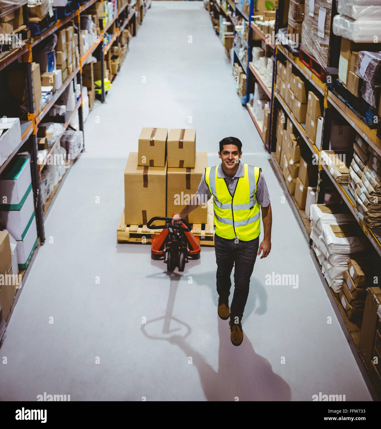 Worker pulling trolley with boxes Stock Photo - Alamy