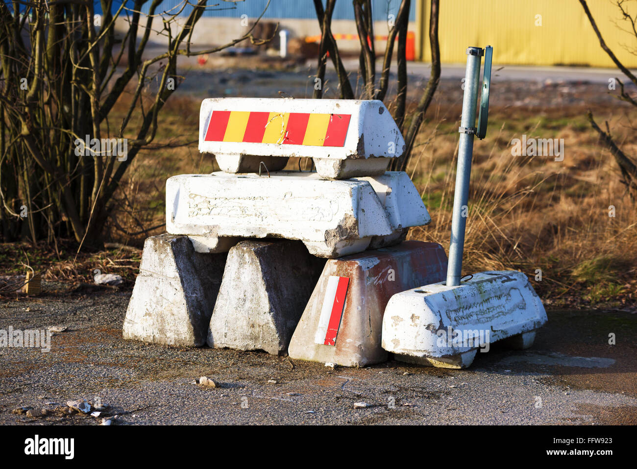 A small stack of concrete road blocks and a traffic sign at the ...