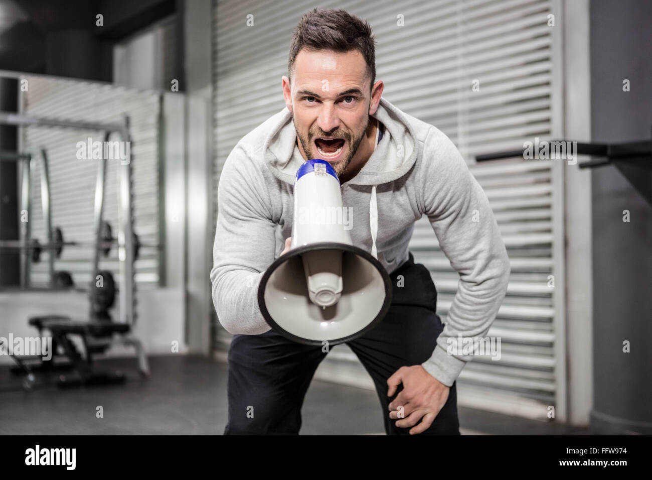 Muscular man shouting on megaphone Stock Photo - Alamy