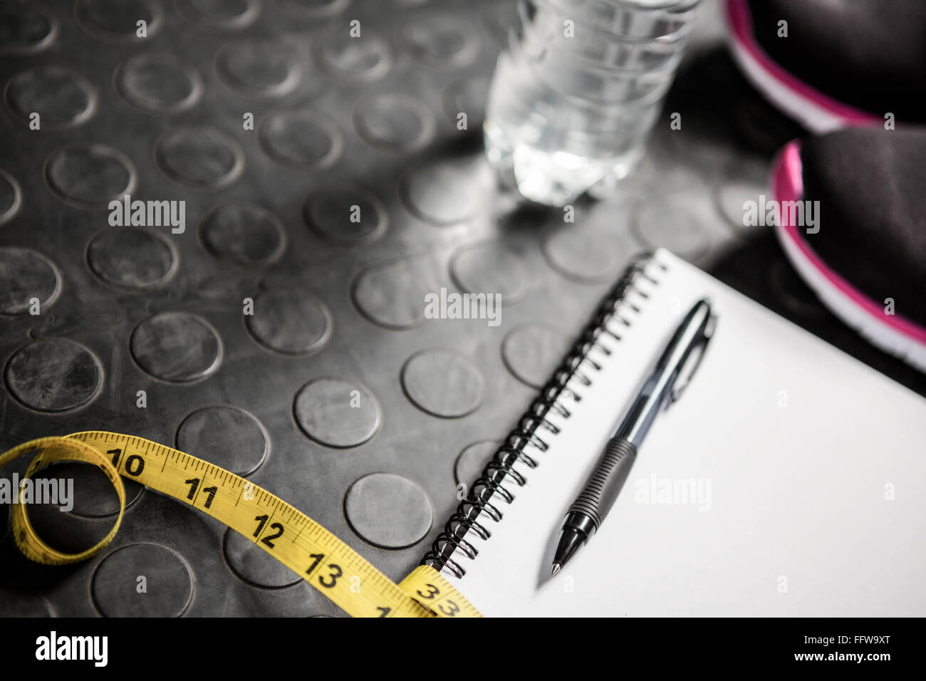 Notepad, measuring tape, shoes and bottle Stock Photo - Alamy