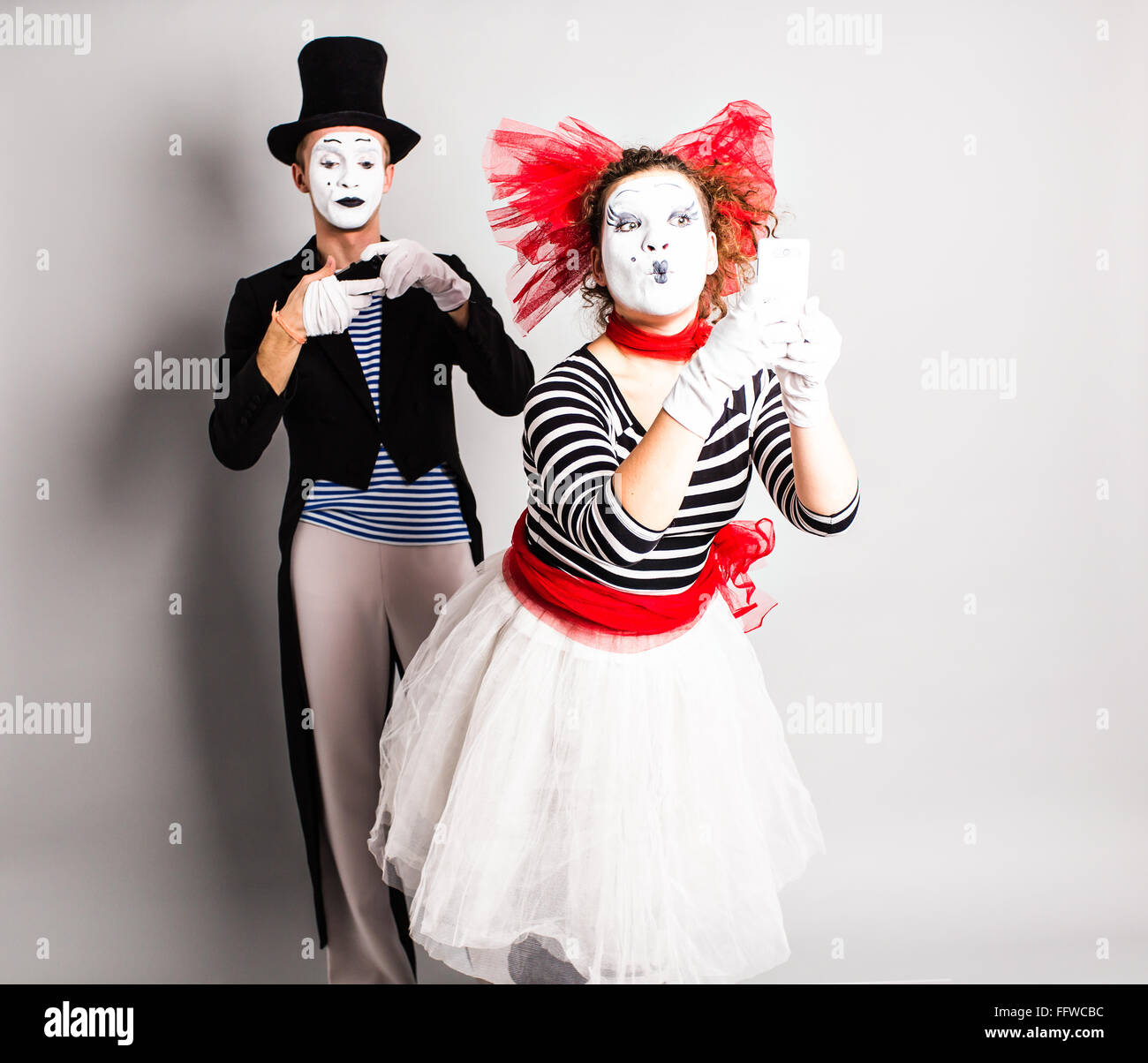 Funny couple of mimes taking a selfie photo on a mobile phone. Concept ...