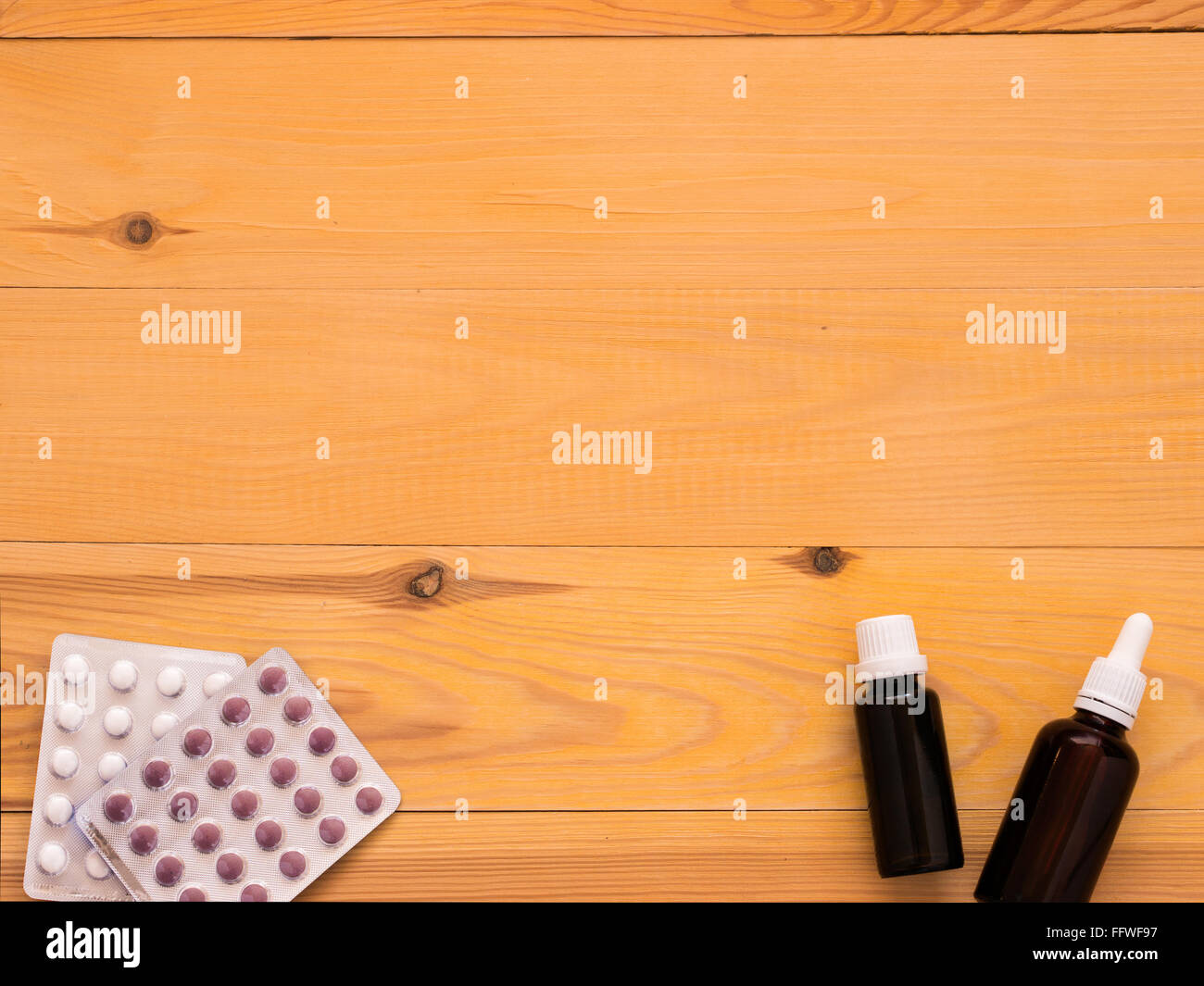 tablets and drops on a light wooden background Stock Photo - Alamy