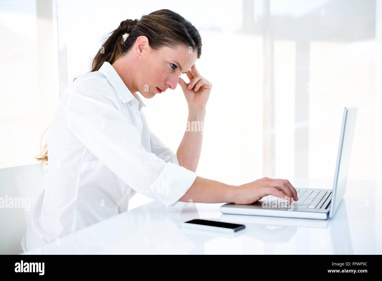 serious business woman typing on her laptop Stock Photo - Alamy
