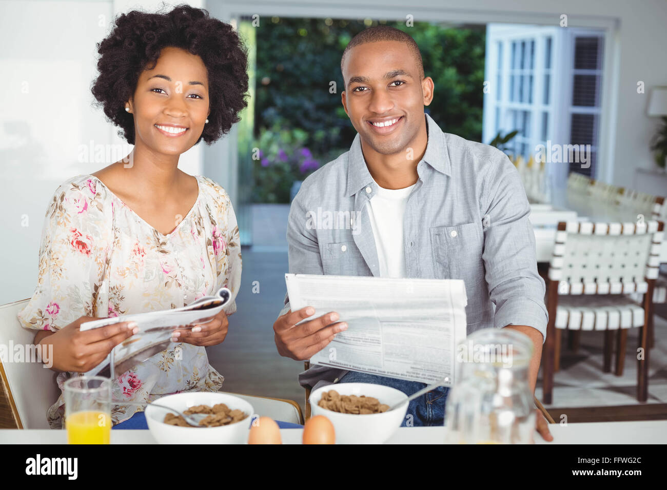 Smiling couple reading magazine and documents during breakfast Stock ...