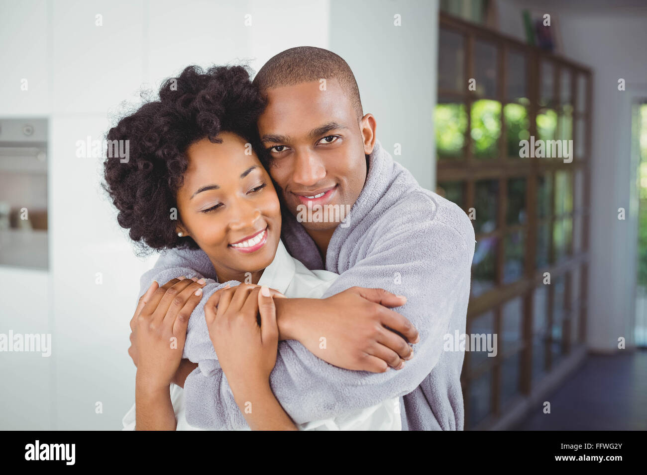 Happy couple hugging in the kitchen Stock Photo - Alamy