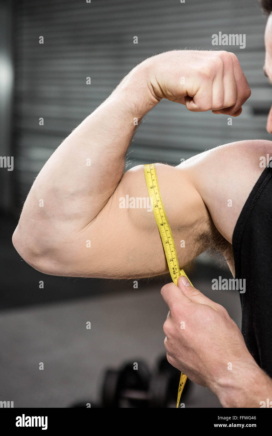 Muscular man measuring biceps Stock Photo - Alamy