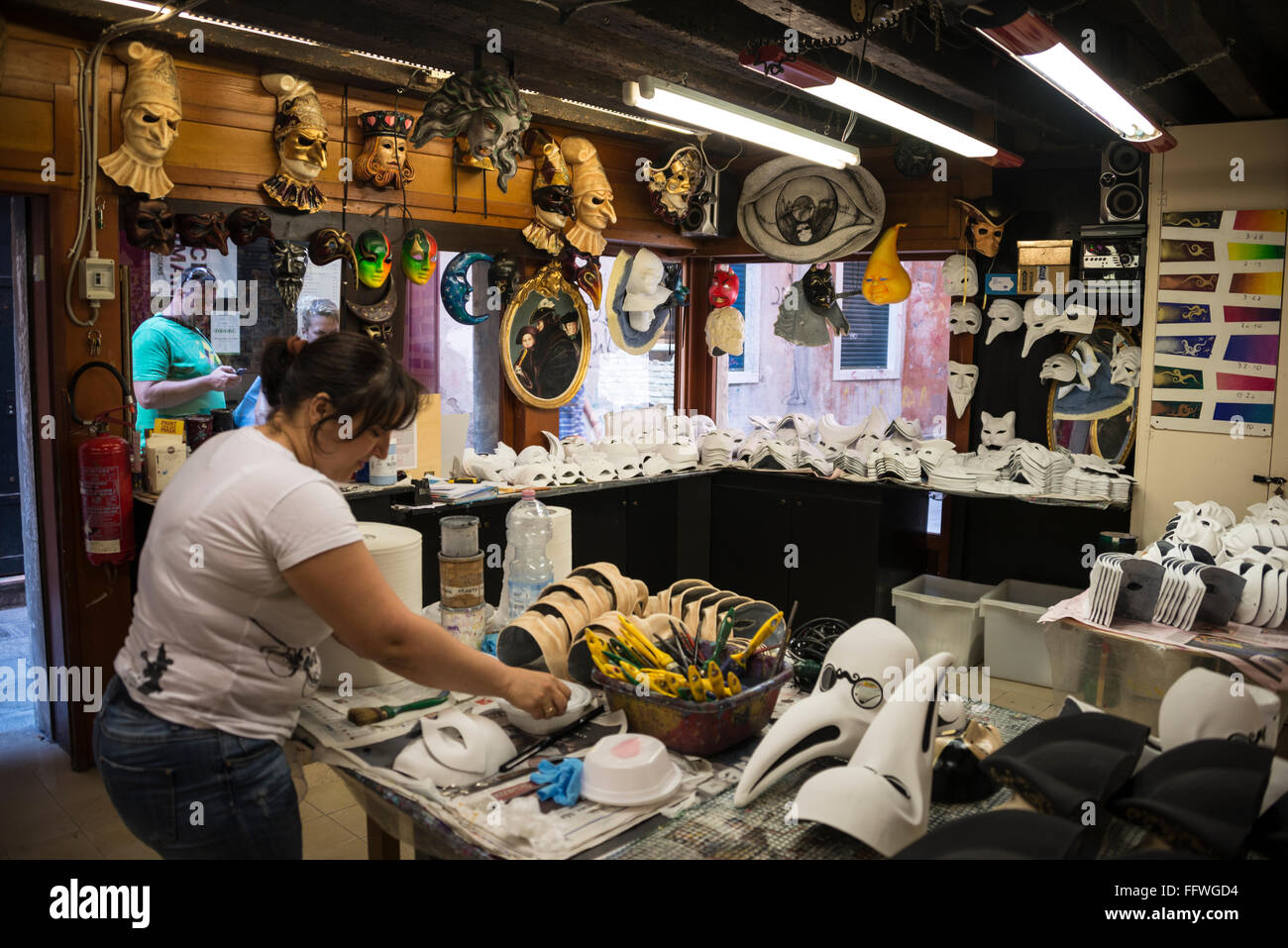 An artist hand painting a face mask for a costumer in a handmade mask ...