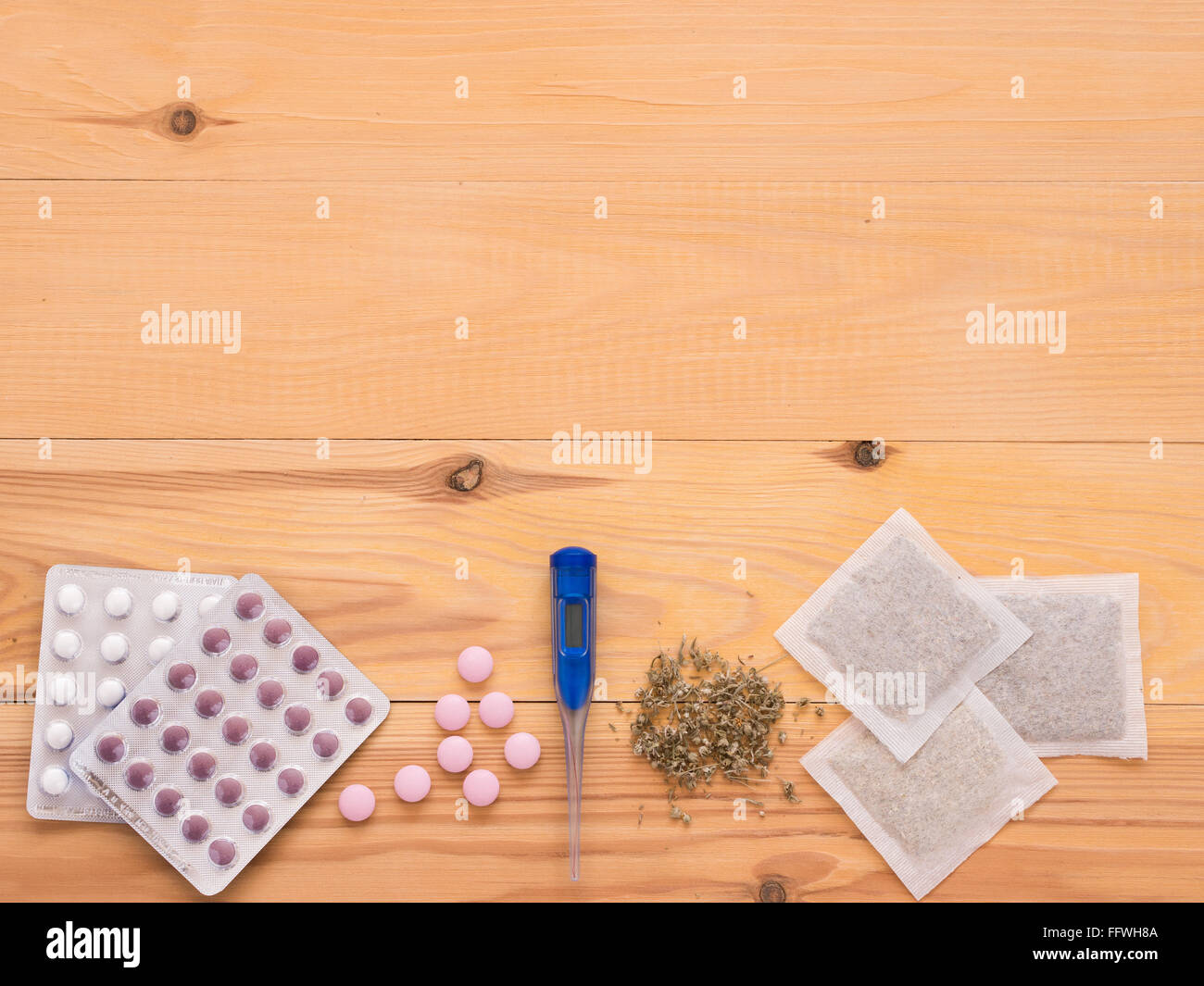 tablets, drops, herbals and thermometer on a wooden background Stock ...