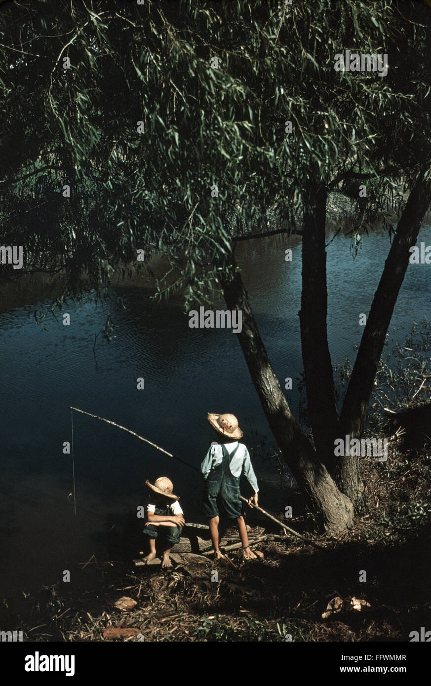 BAYOU FISHING, 1940. /nTwo Cajun boys fishing in a bayou creek in ...