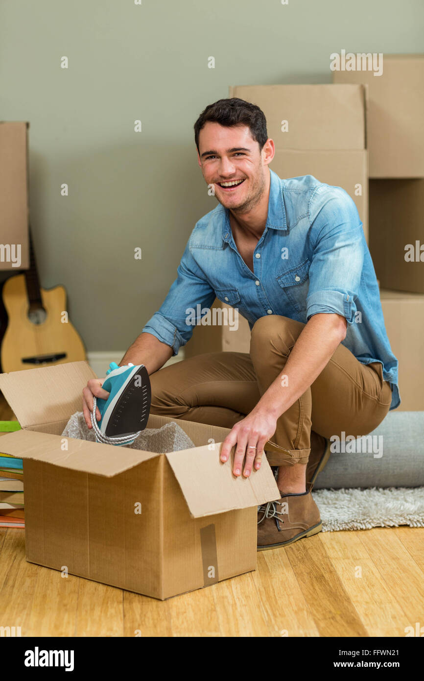 Young man unpacking carton boxes Stock Photo - Alamy