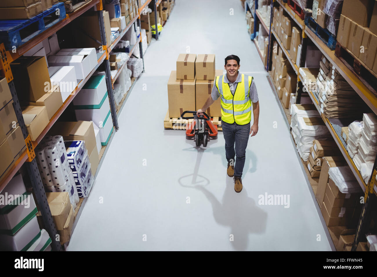 Worker pulling trolley with boxes Stock Photo - Alamy