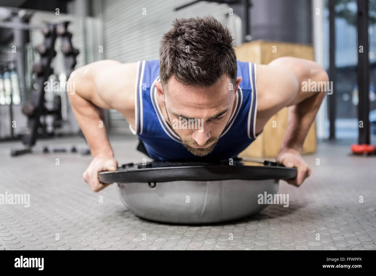 Muscular man doing push up on bosu ball Stock Photo - Alamy