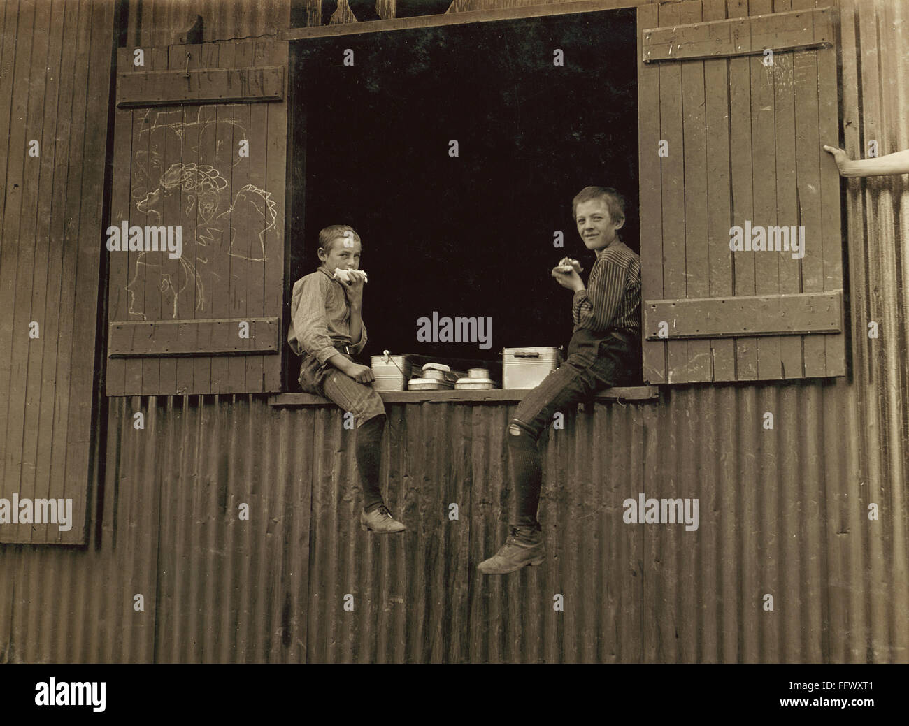 HINE: CHILD LABOR, 1908. /nTwo boys eating lunch on a window ledge at ...
