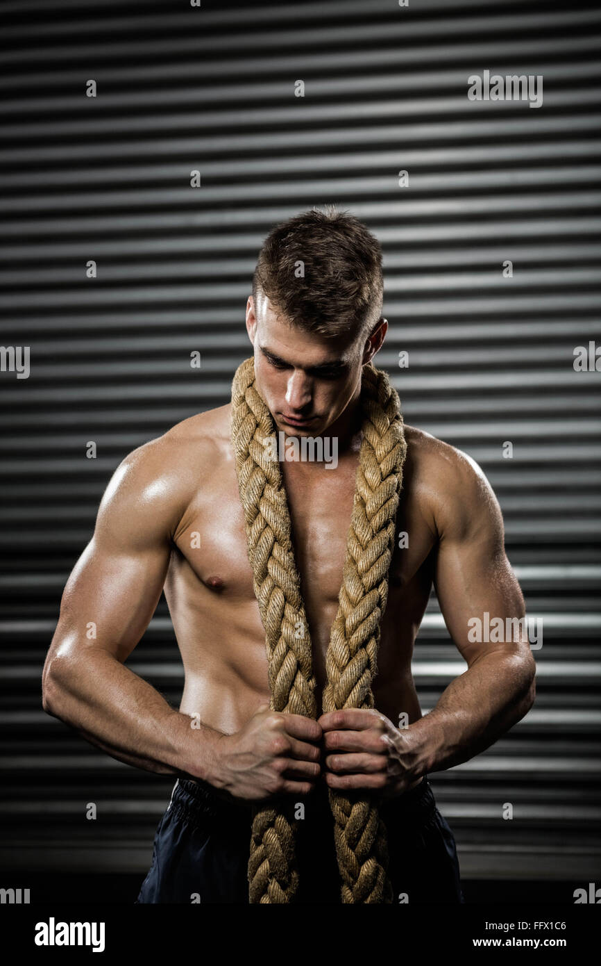 Shirtless man with battle rope around neck Stock Photo - Alamy